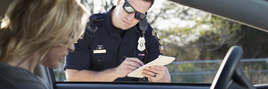 Police officer writing ticket - California Ticket King, PC